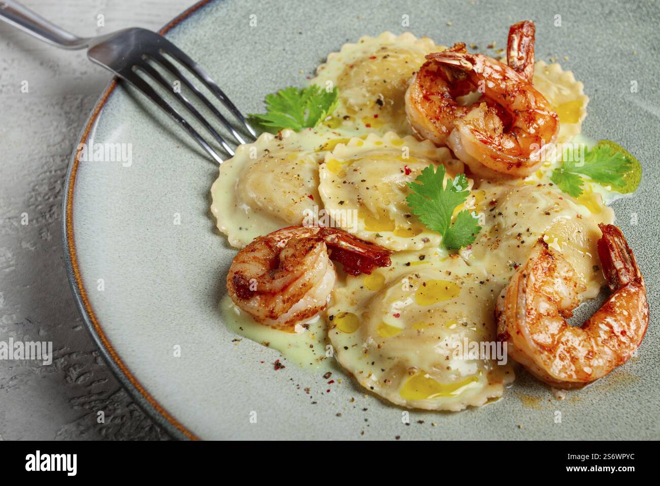 Ravioli with shrimp, in cream sauce, with spices and herbs, top view ...