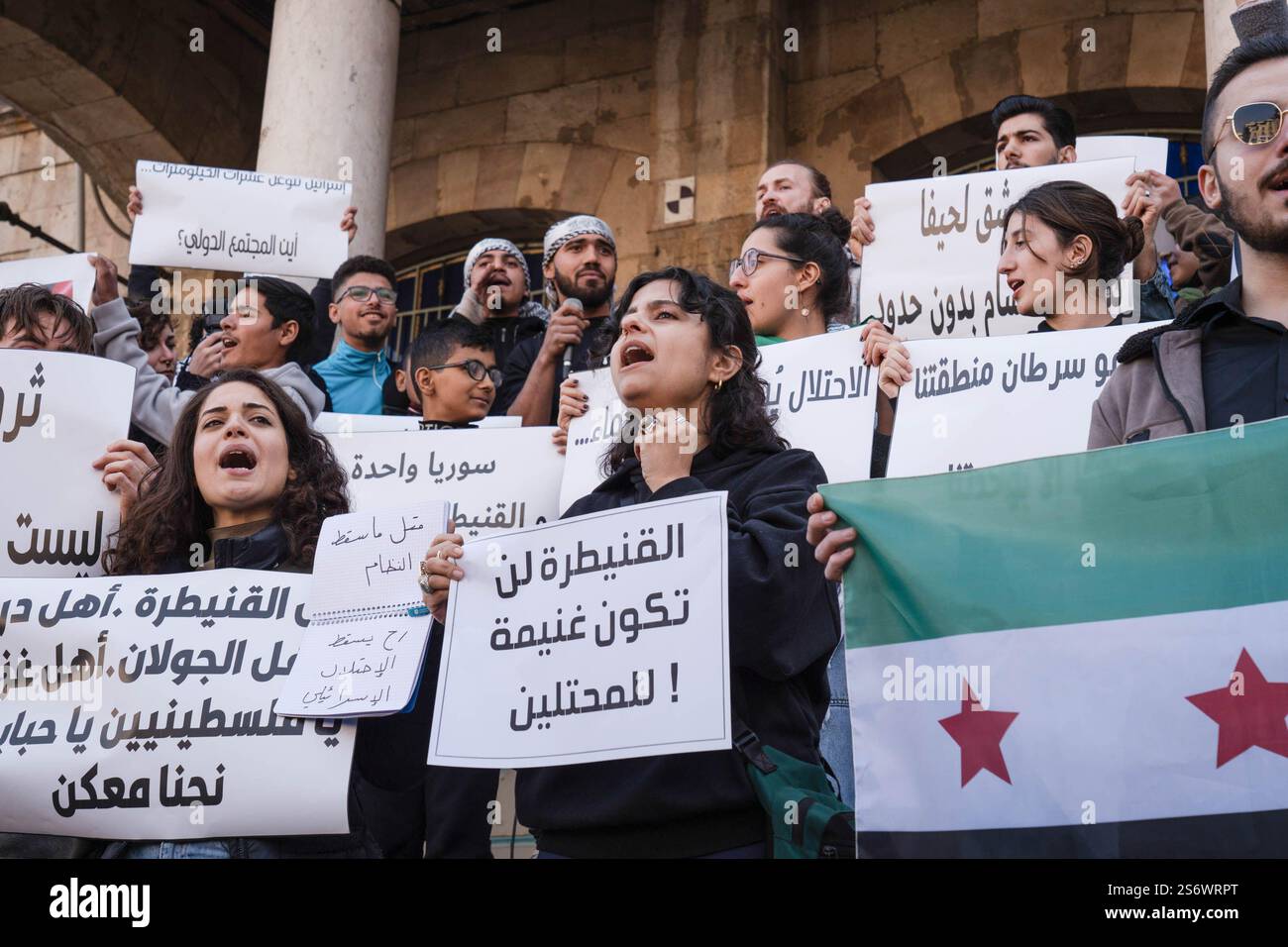Damascus, Syria. 17th Jan, 2025. A crowd is seen holding placards and ...