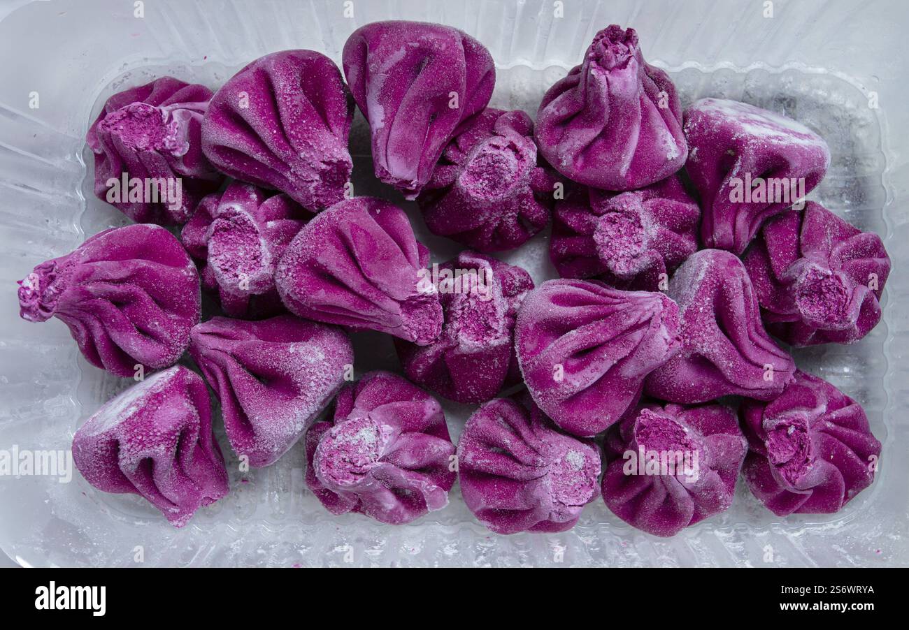 Freshly frozen beetroot khinkali, in a container, top view, no people ...