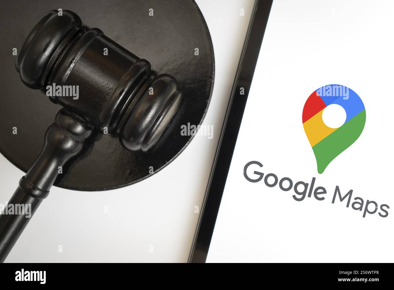 An iPad displays the Google maps logo alongside a judge's gavel Stock ...