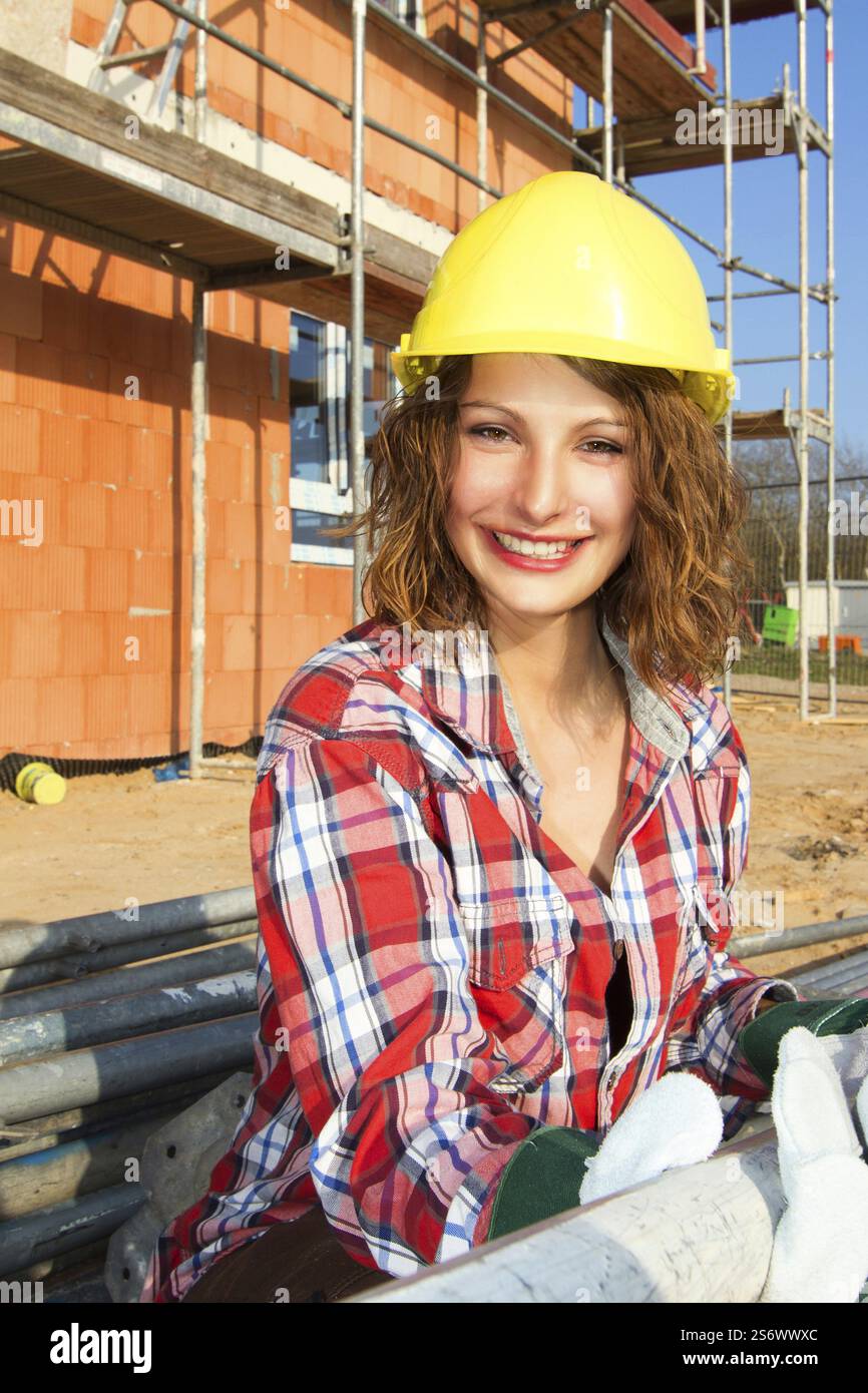A craftswoman in front of the shell of a house, woman, female, 30 ...
