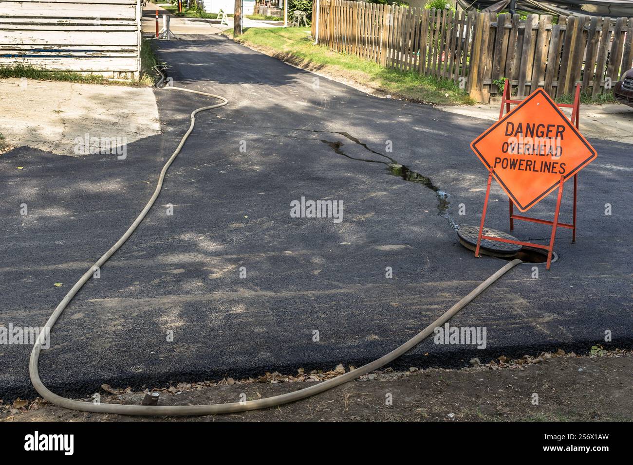 Warning at manhole indication danger overhead Stock Photo - Alamy