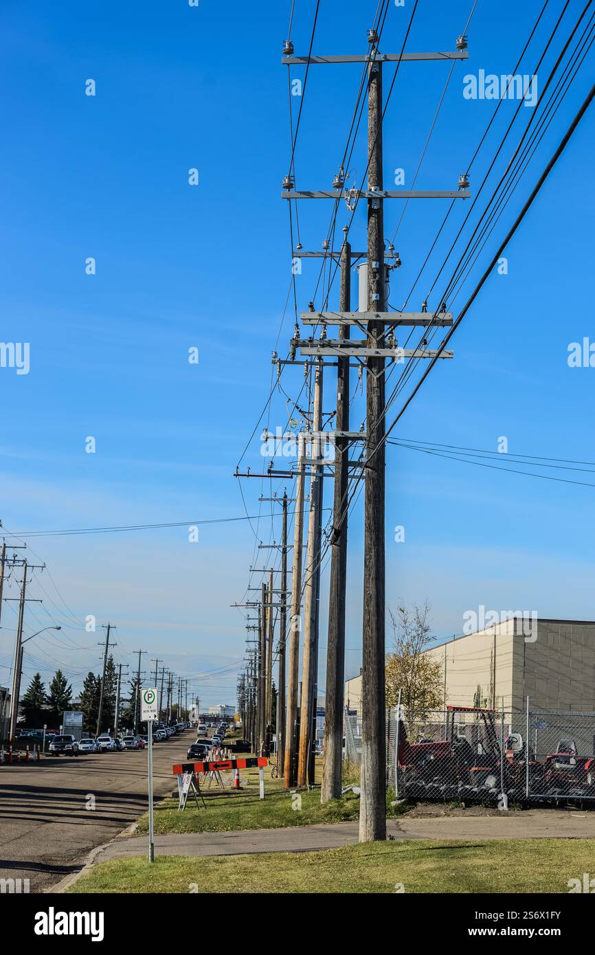 Street view with a row utility poles, construction signs in the front ...
