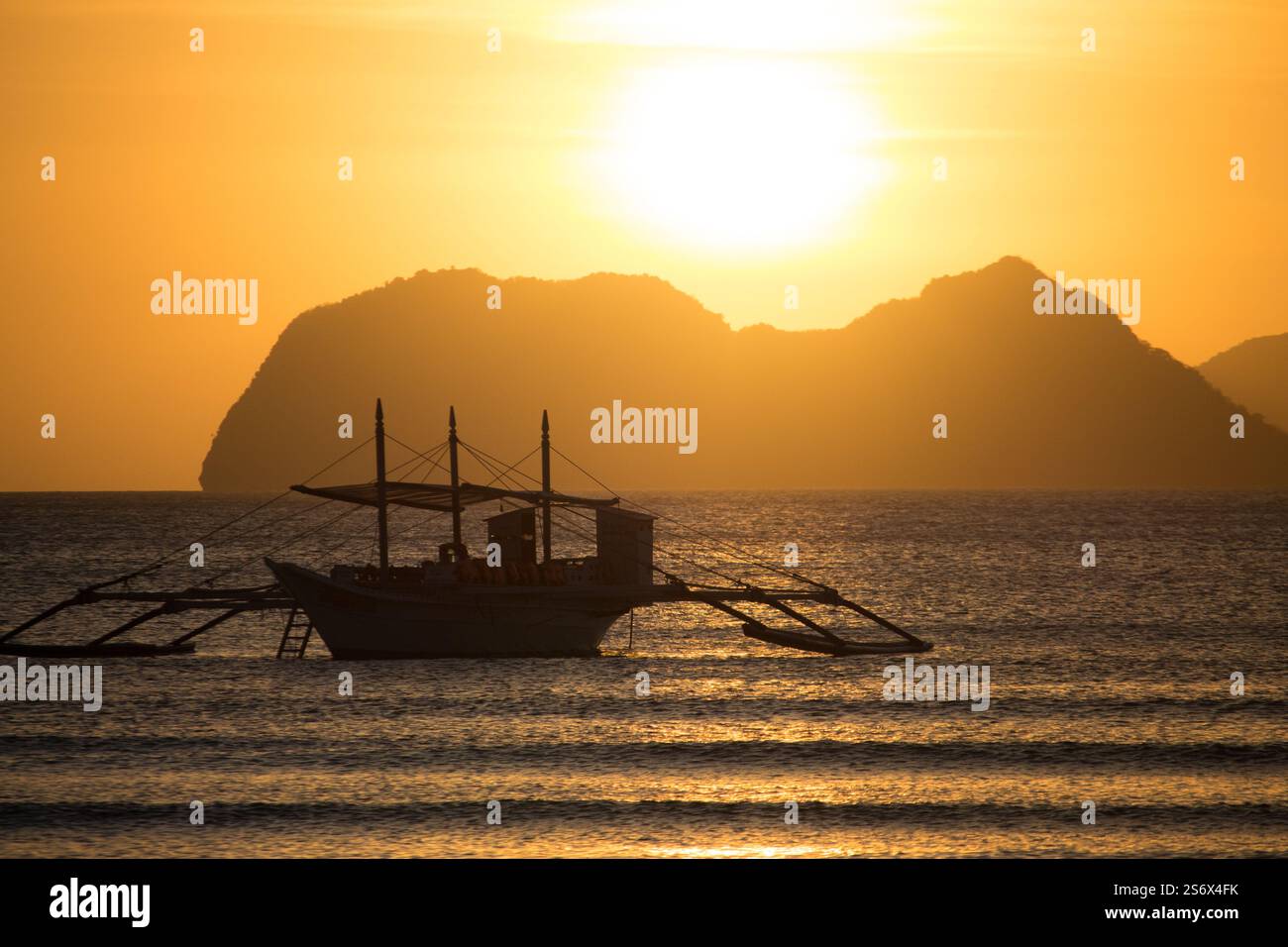 Local boats in tropical harbour in evening dusk. Sunset in lagoon in ...