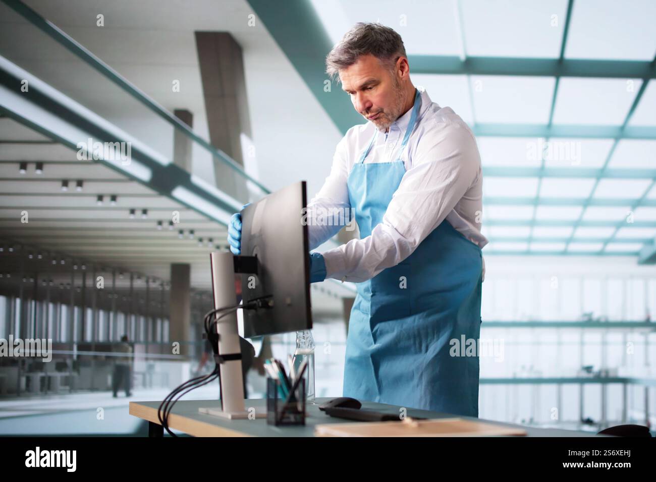 Man Cleaning Computer Monitor With Rag In Office Stock Photo - Alamy