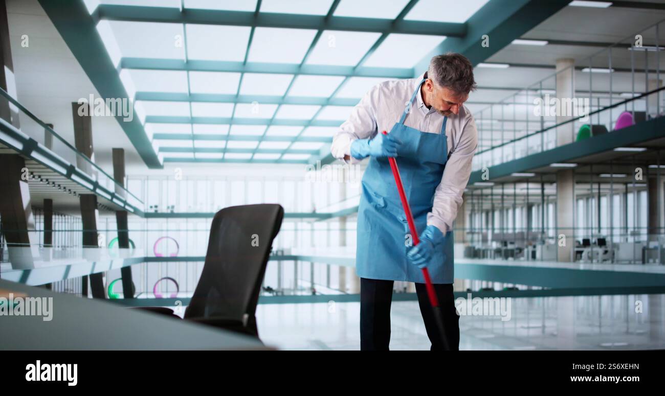 Male Janitor Cleaning Floor With Mop In Office Stock Photo - Alamy