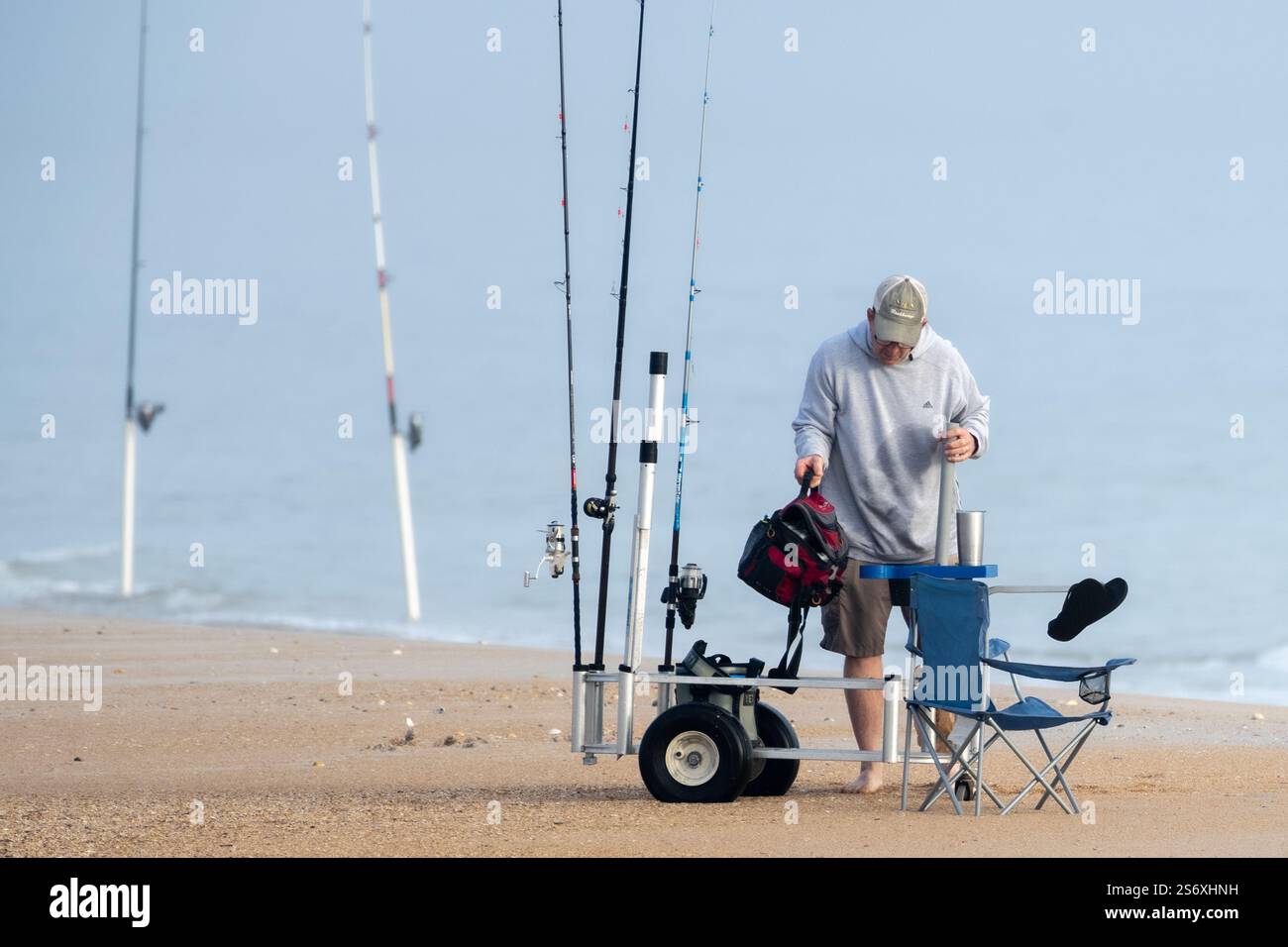 Beach fisherman on a foggy morning just after sunrise along the ...
