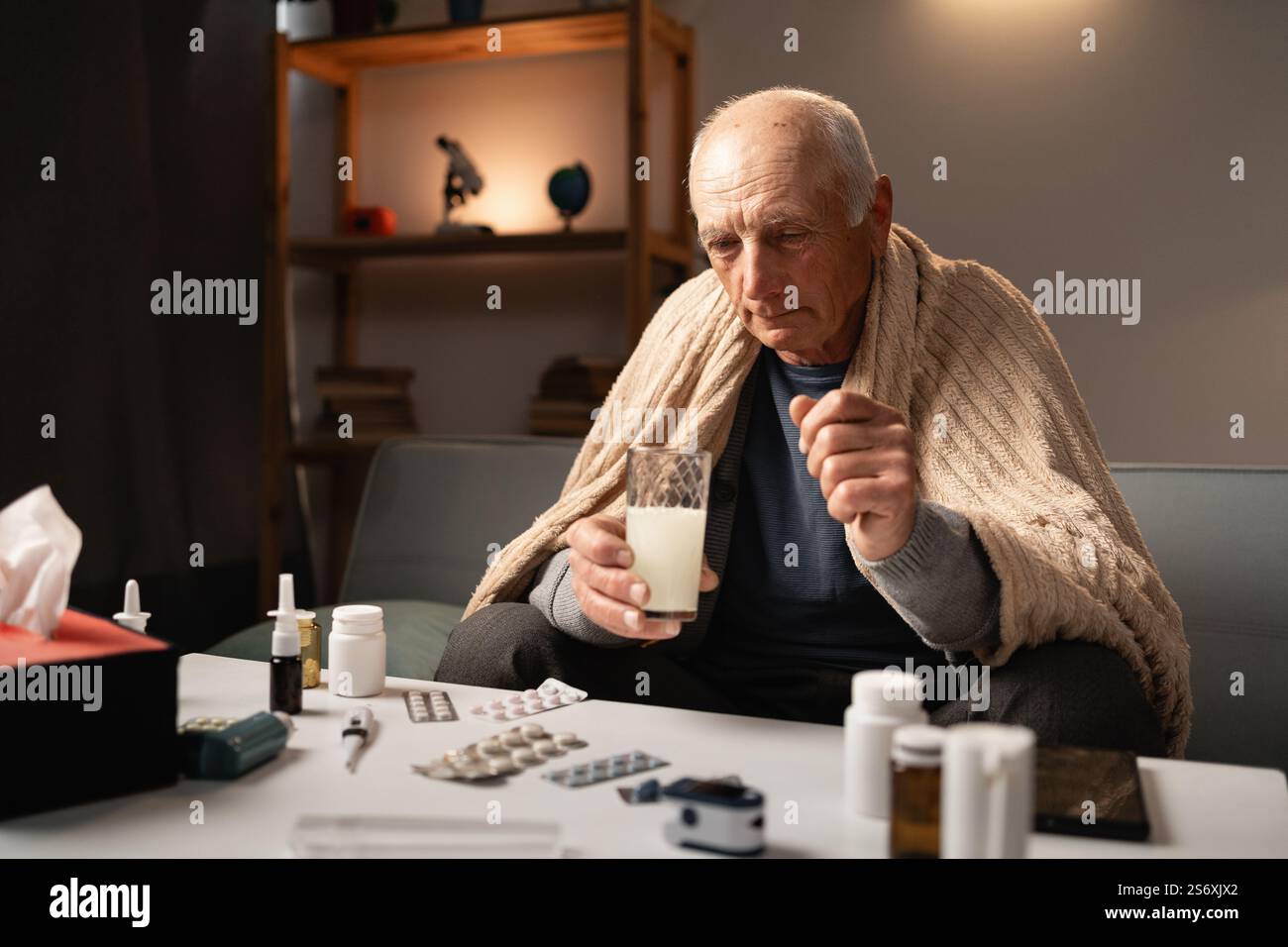 Retired man suffering from fever and headache drinking effervescent ...