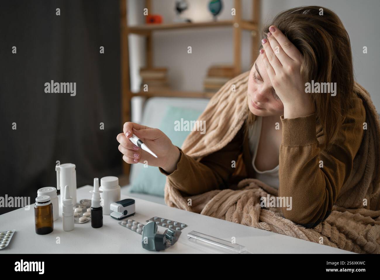 An unhappy young woman suffering from flu, fever and headache looks ...
