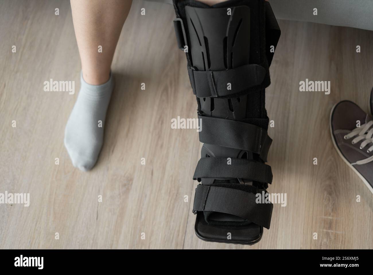 Injured leg in orthopedic boot recovery Stock Photo - Alamy