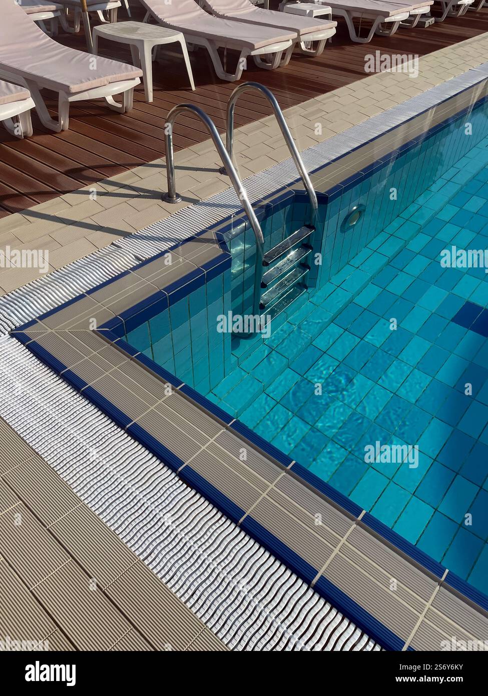 Handrail stairs to the blue pool.Pool with stairs and water. Stainless ...