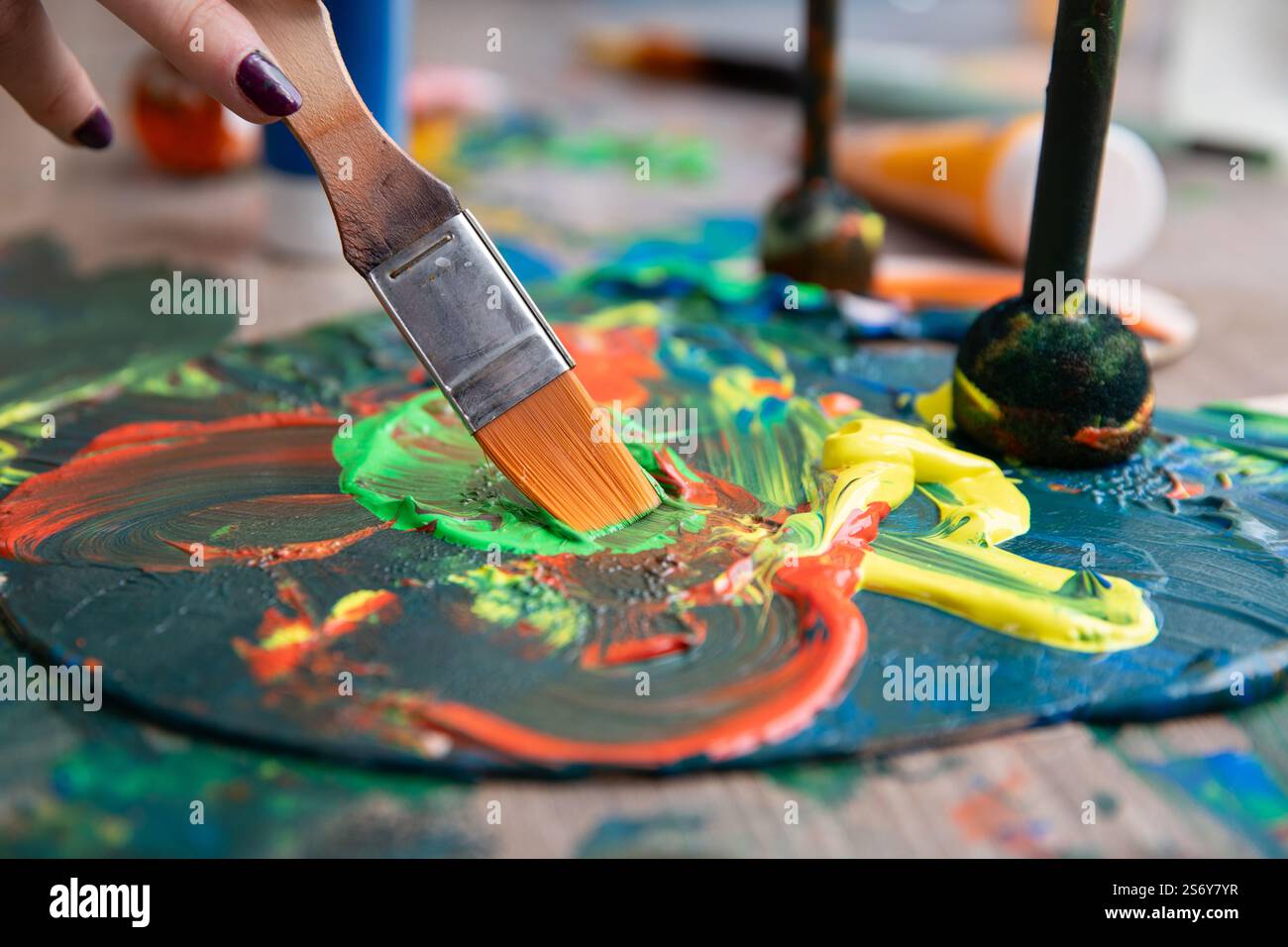 Engaging in Creative Art Mixing Paint on Canvas with Brushes for ...