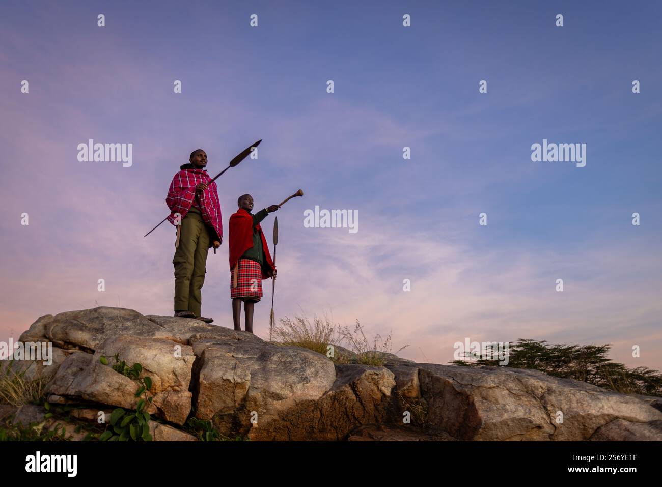 Close-up of a Maasai warrior’s hand holding a spear, silhouetted ...