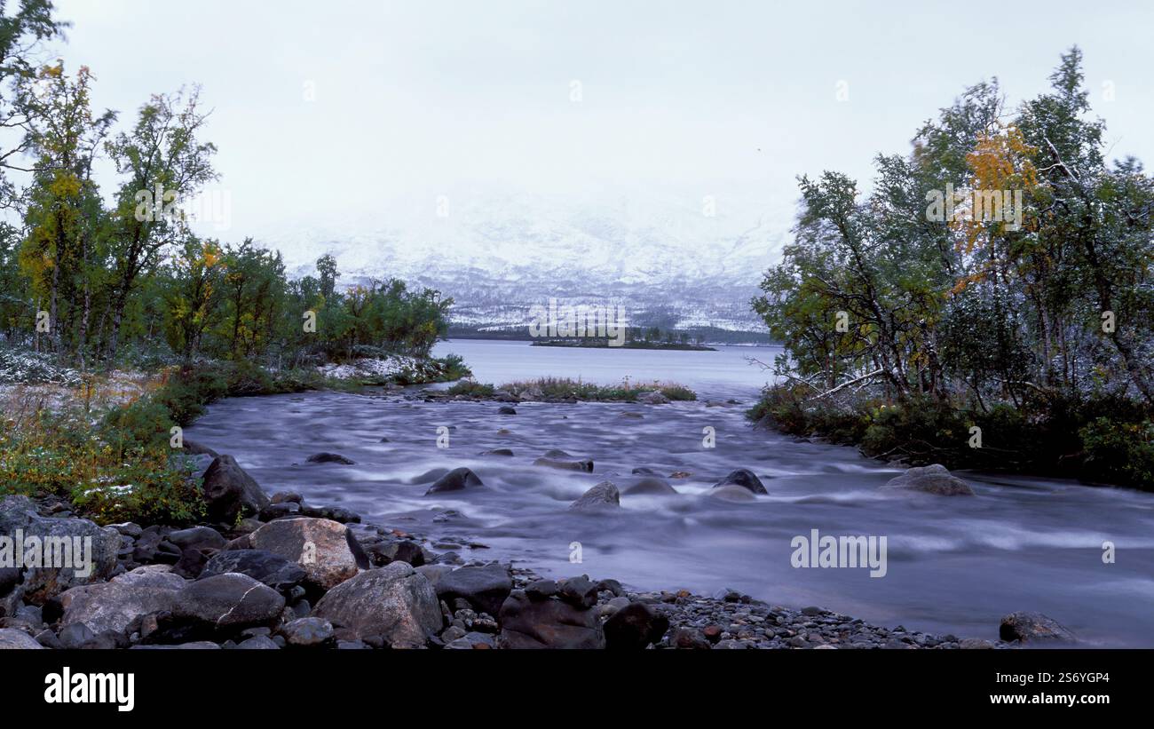 A creek, brook in the Scandinavian mountains. First snow on the ground ...
