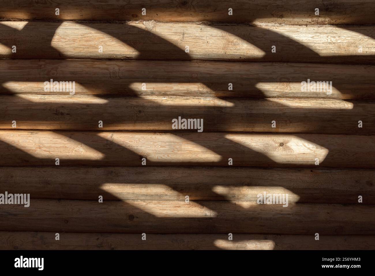 New wooden wall made of uncolored natural pine tree logs with light and ...