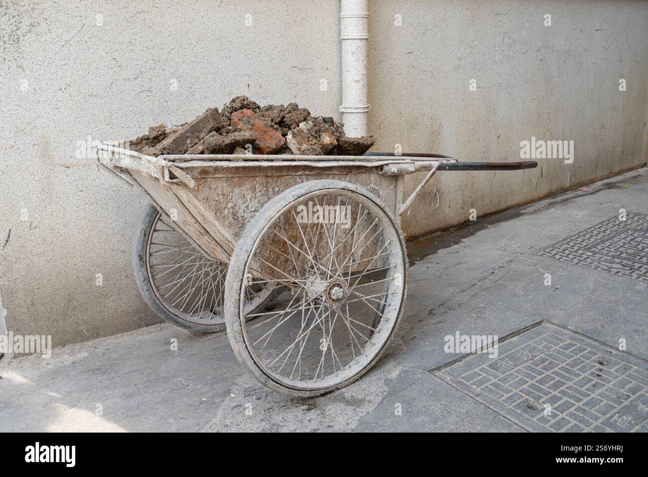 an old wheelbarrow on the sidewalk Stock Photo - Alamy