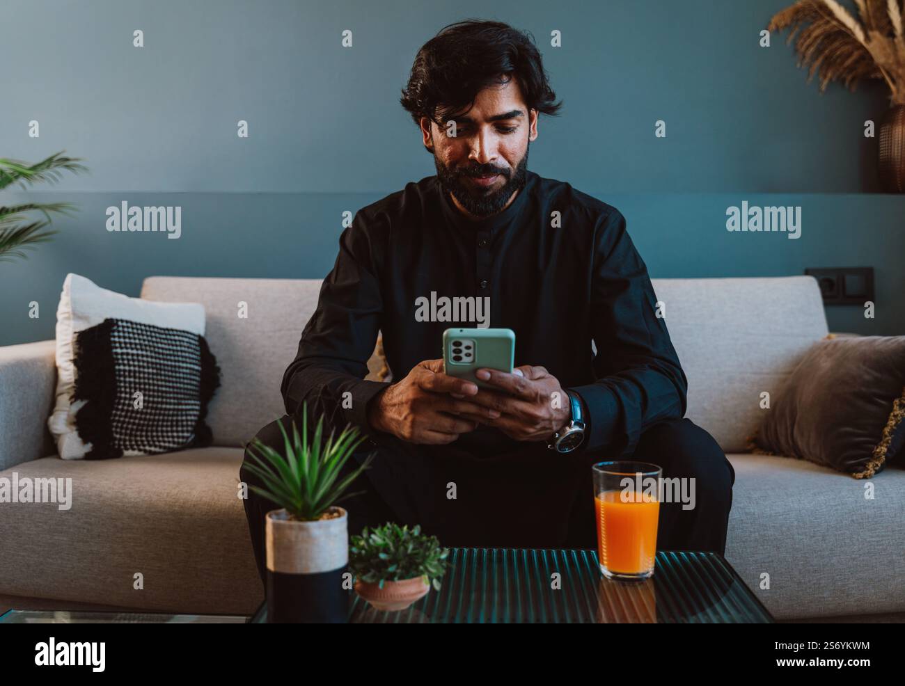 Pakistani young manwith traditional outfit using smart phone on the ...