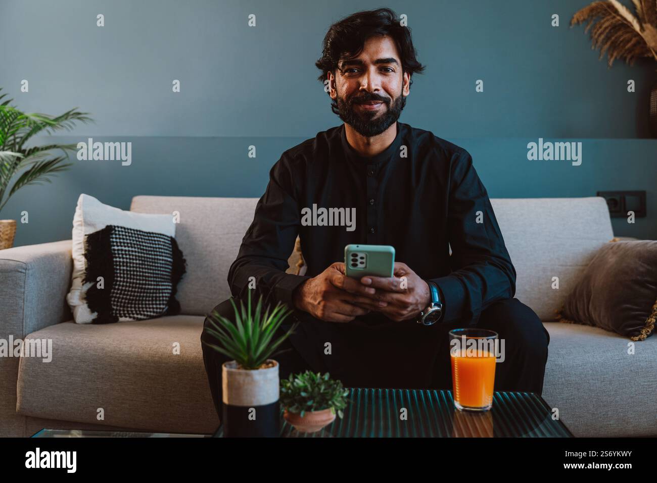 Pakistani young manwith traditional outfit using smart phone on the ...