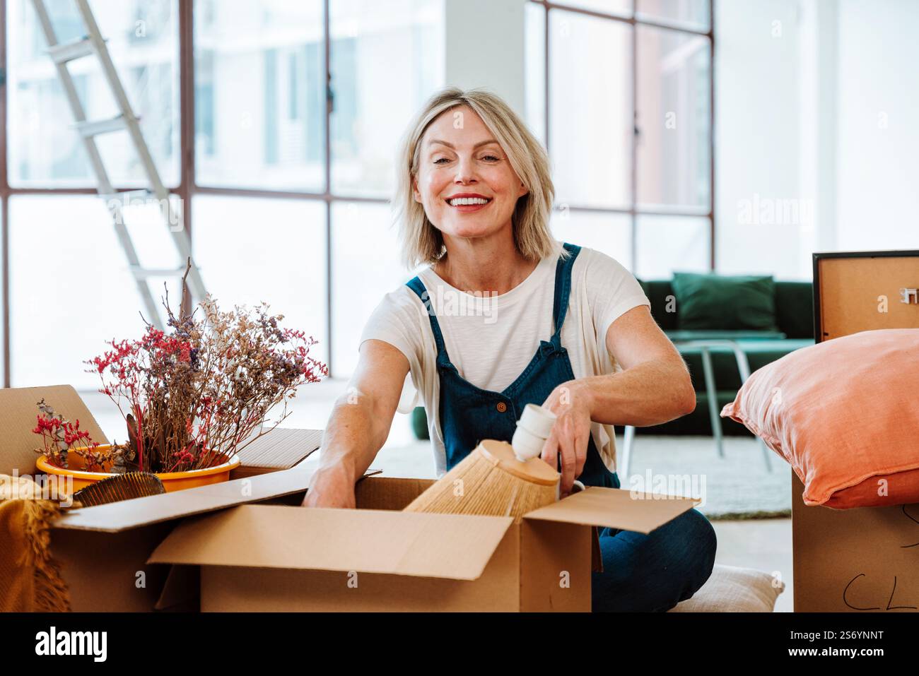 Single woman relocating in a new apartment. Middle aged senior ...
