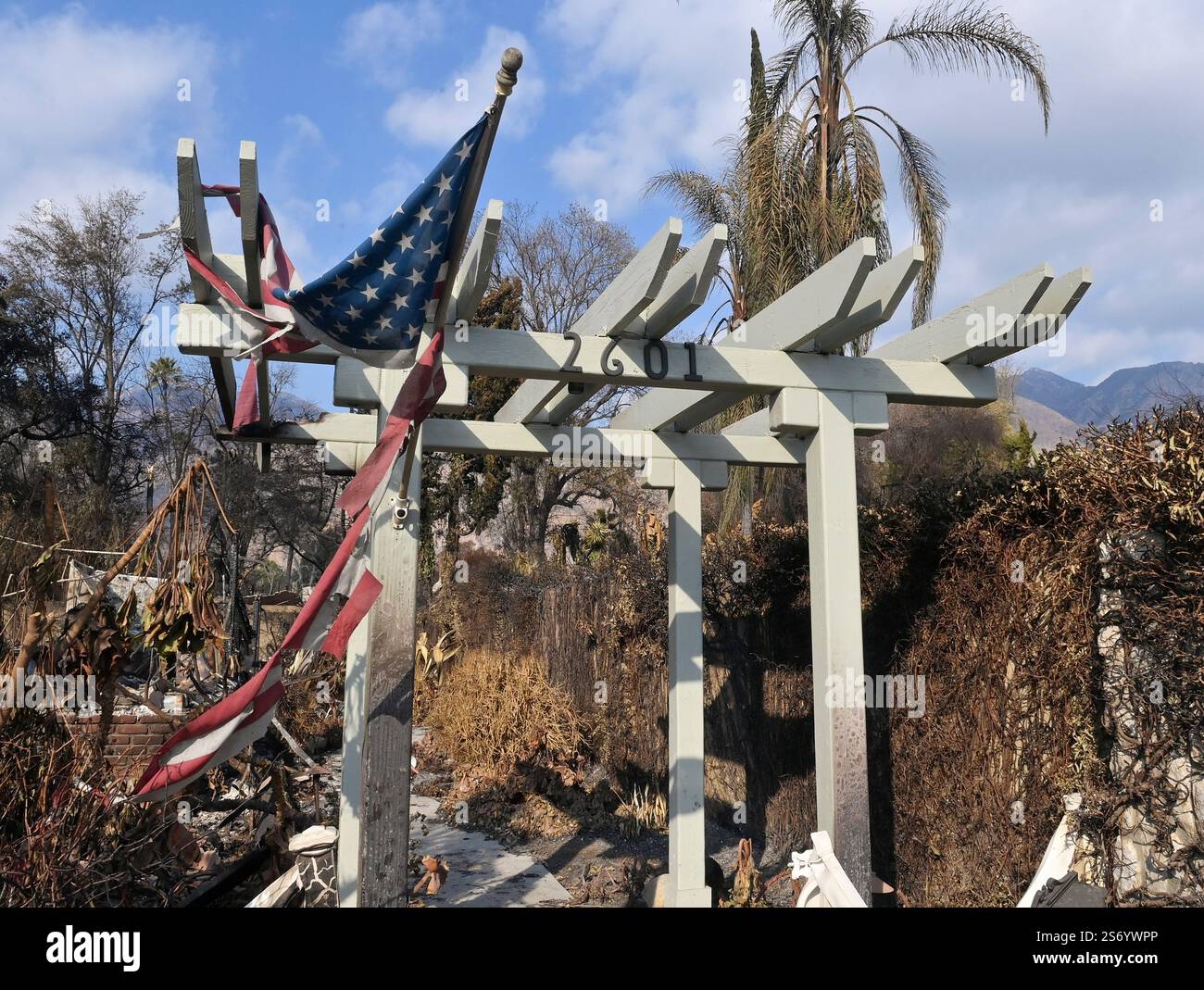 A tattered American flag is all that remains of a house destroyed in ...