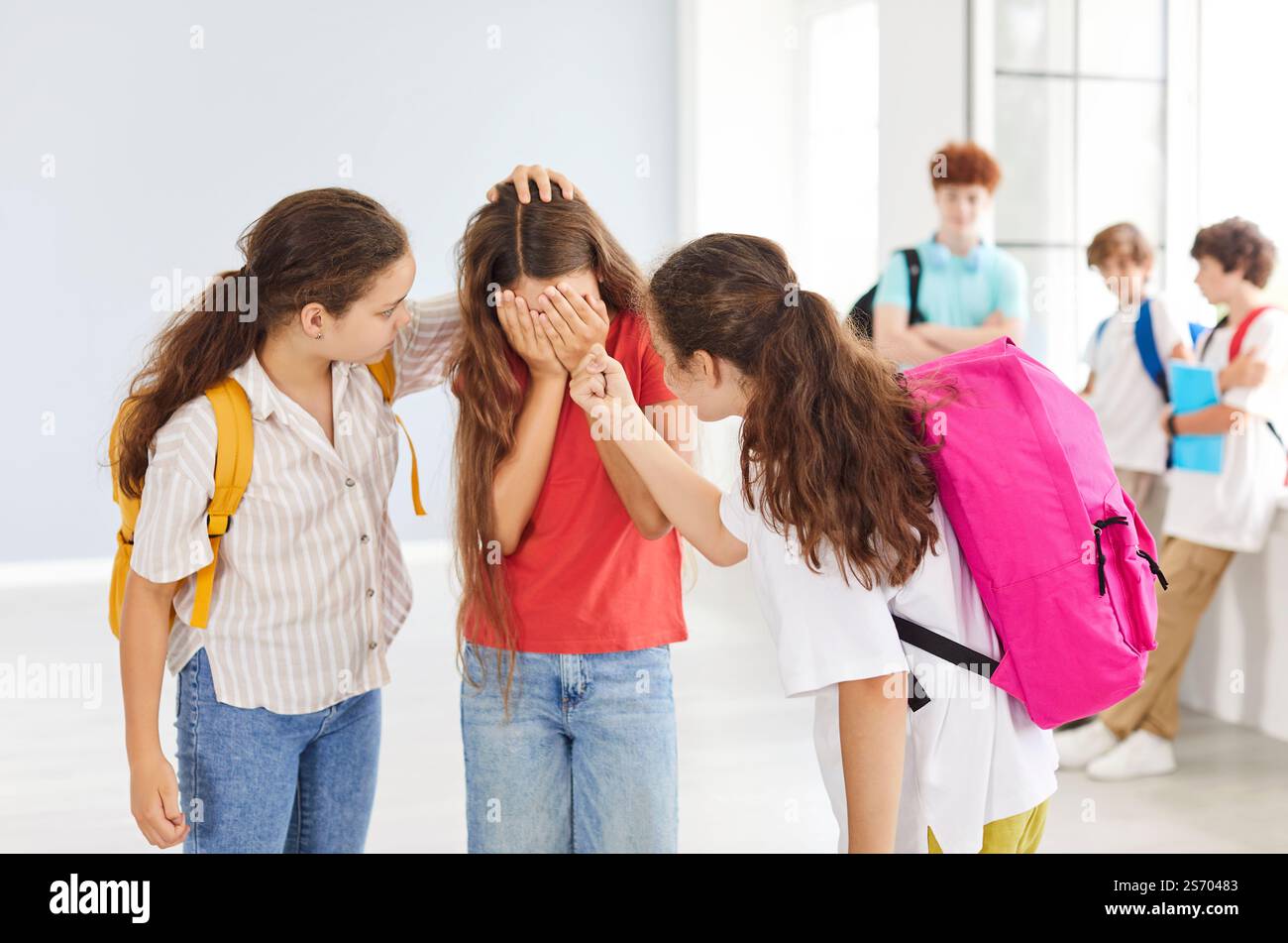 Sad preteen girl bullied by classmates in school corridor, covering her ...