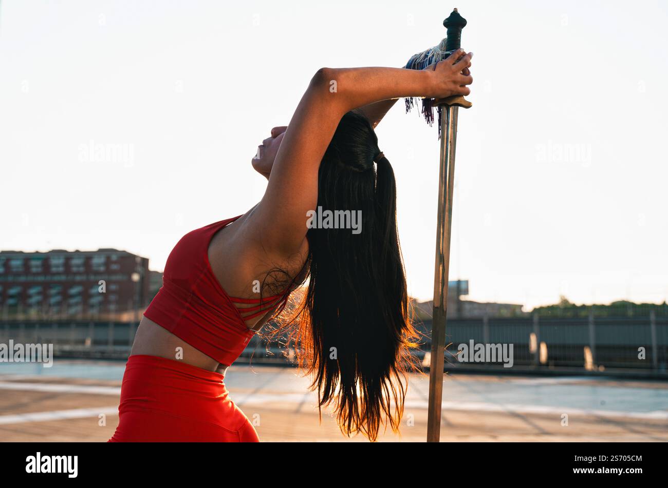 Chinese young woman practicing wushu kung fu with weapons outdoor. Young girl training martial ...
