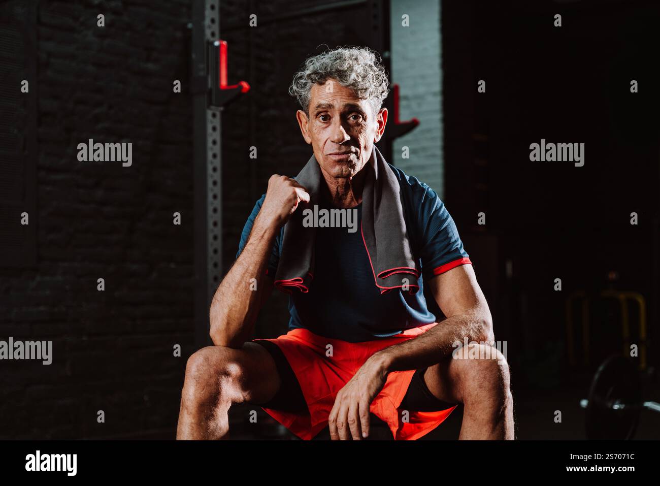 Fit senior man in the gym training with weights. Portrait of a mature ...