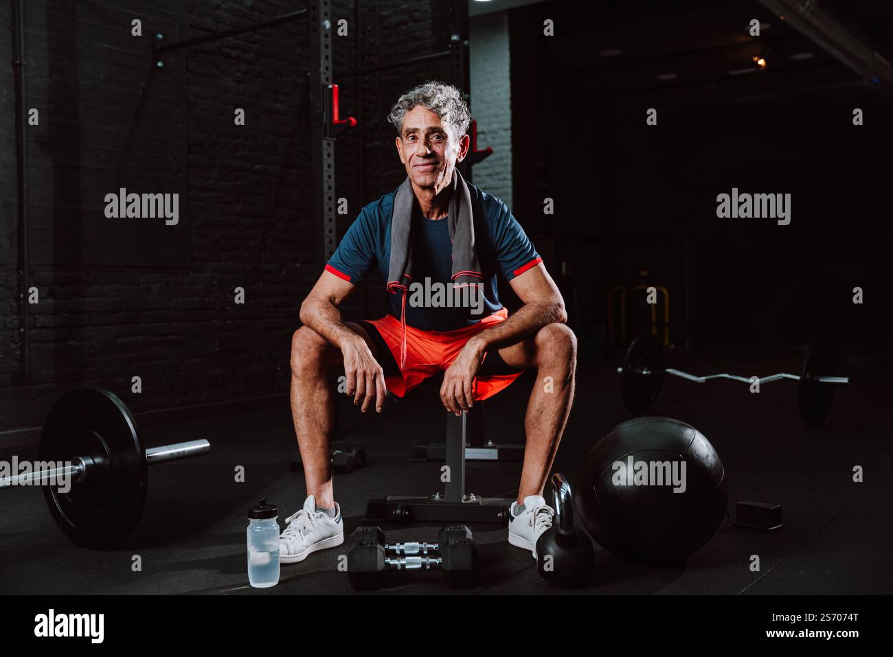 Fit senior man in the gym training with weights. Portrait of a mature ...