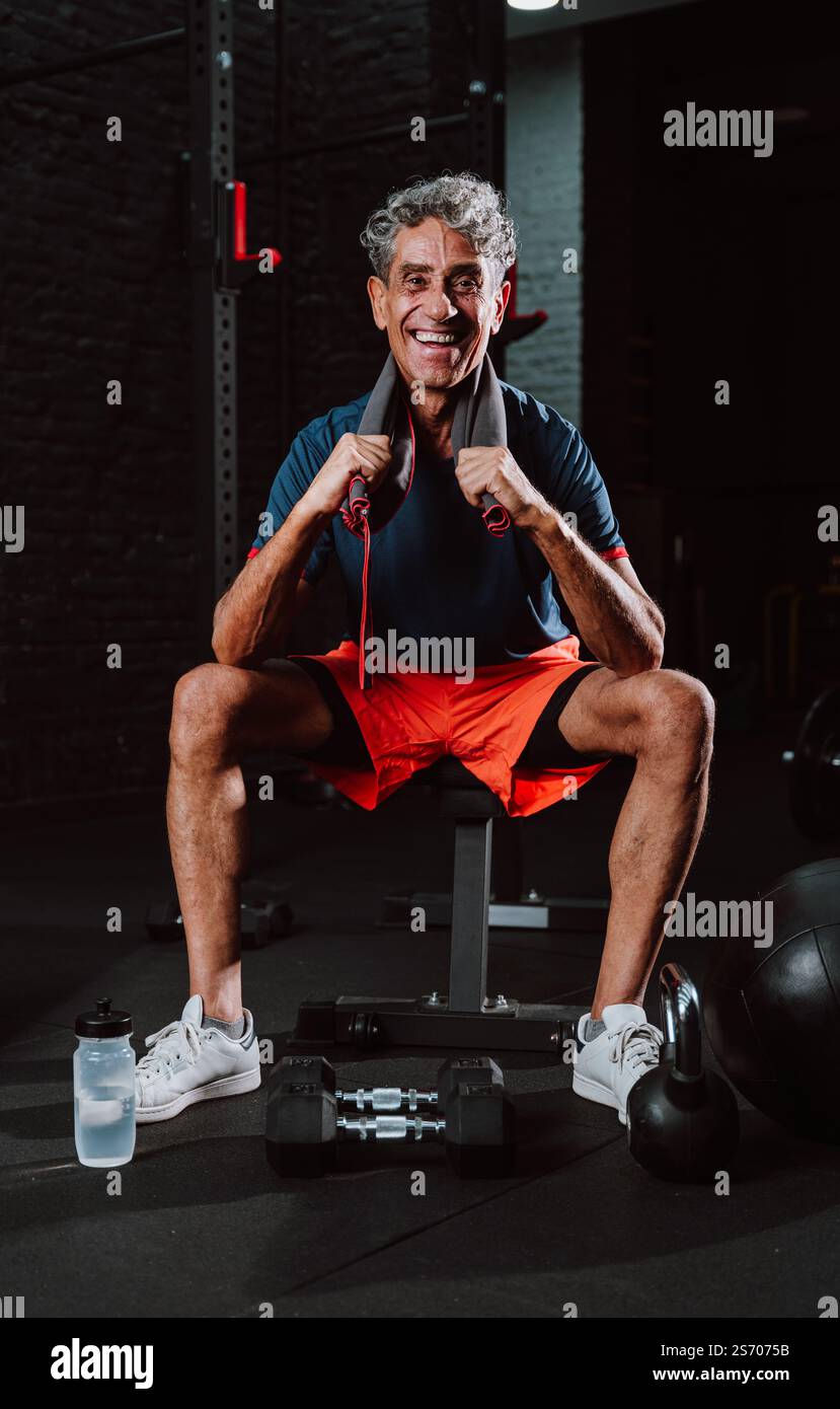 Fit senior man in the gym training with weights. Portrait of a mature ...