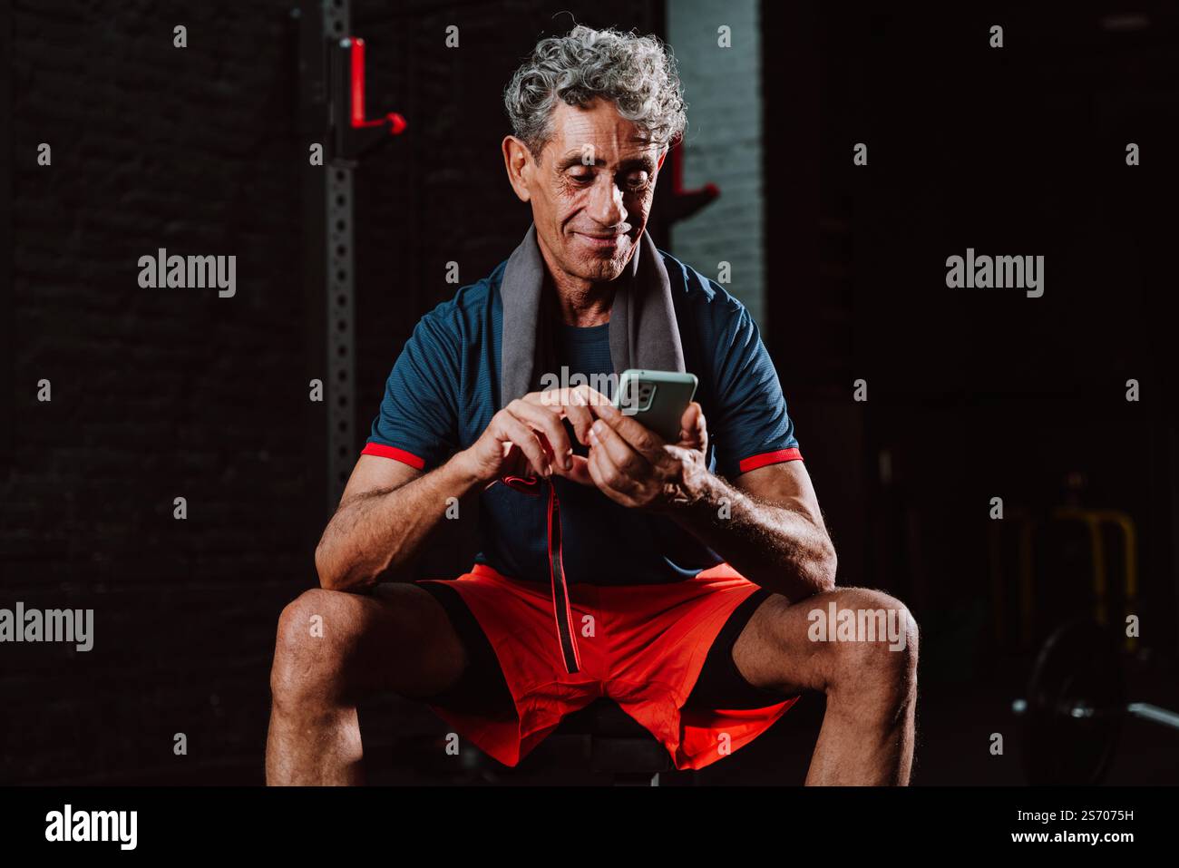 Fit senior man in the gym training with weights. Portrait of a mature ...