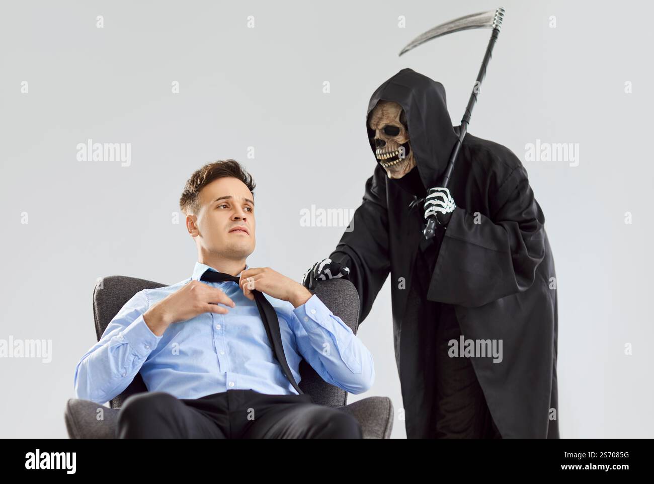 Stressed scared man with person in a Halloween grim reaper death ...