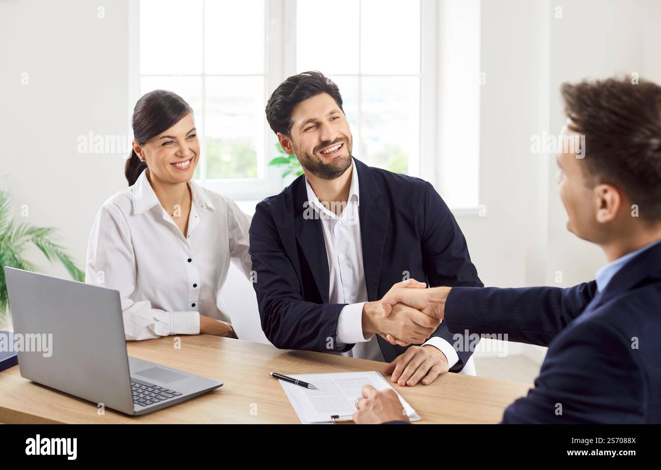 Happy family couple clients handshake to make sale purchase, deal sign ...