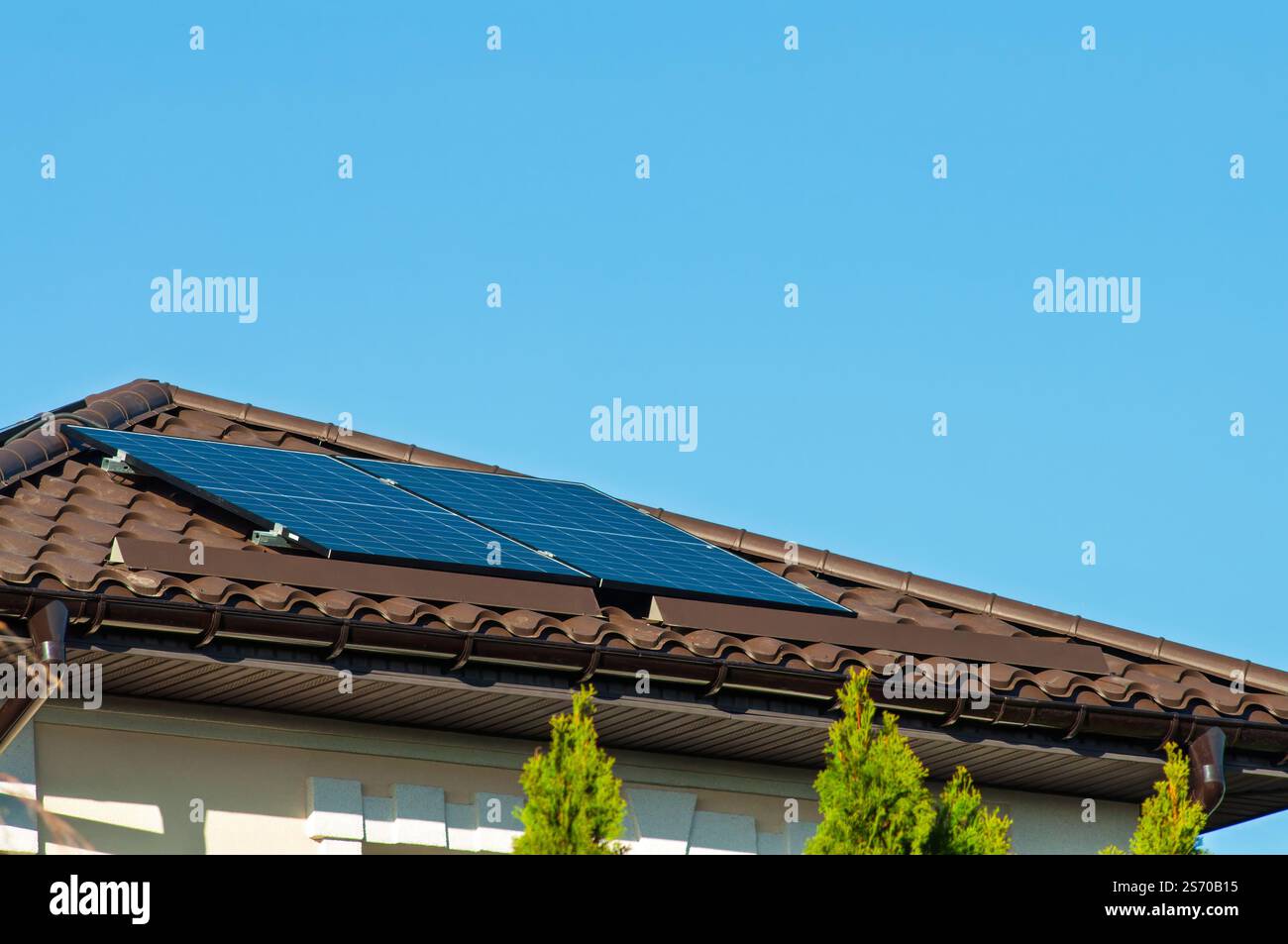 Solar panels installed on a sloped roof of a residential house under ...