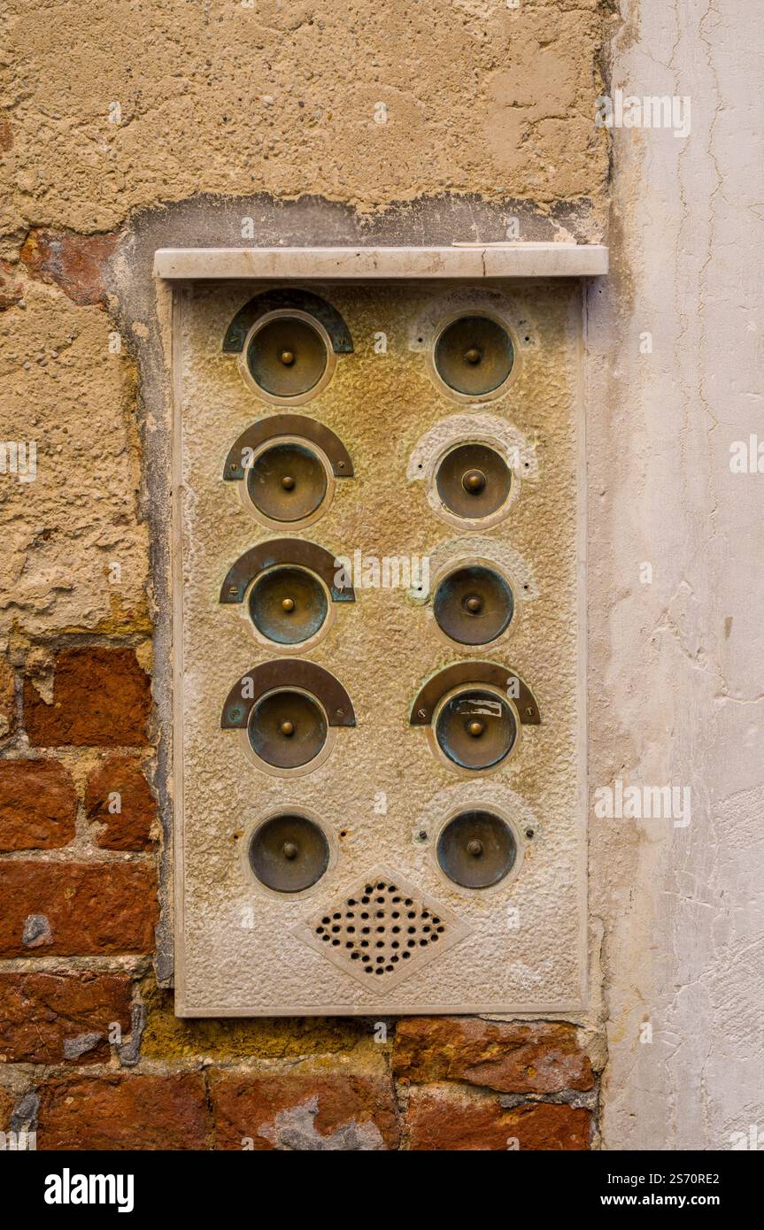 Vintage intercom with multiple buttons mounted on a stucco wall, part ...