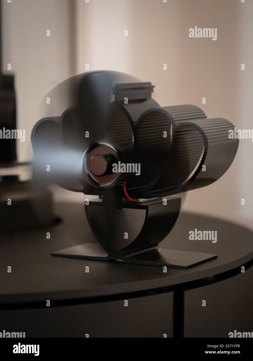 A heat powered stove top fan on a log burning stove Stock Photo - Alamy