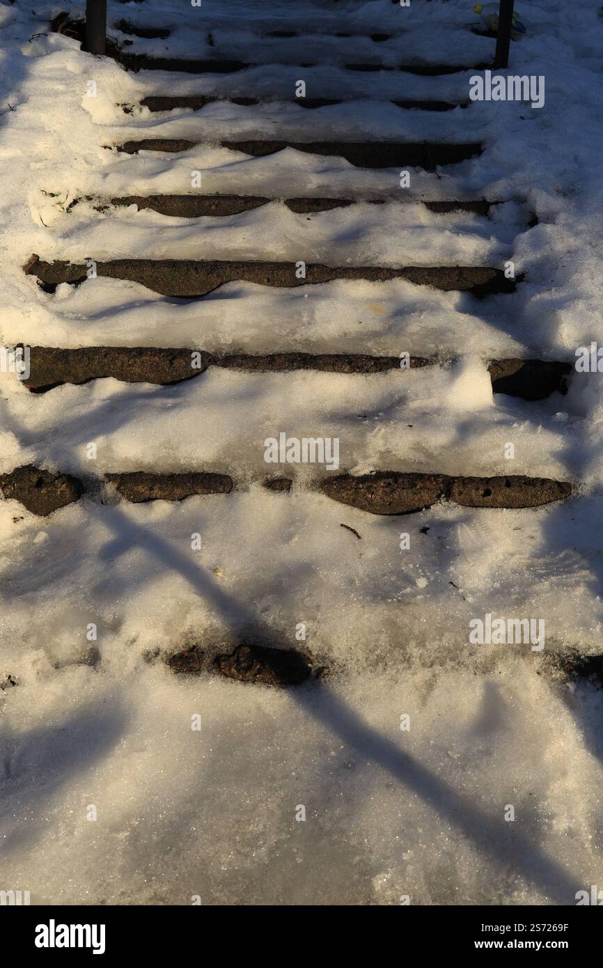 The steps of the street stairs are almost hidden by snow and ice after ...