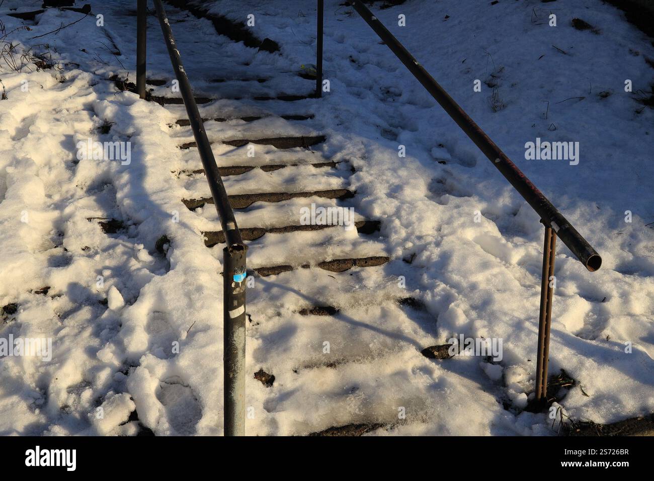 Winter staircase with handrails and steps under snow and ice ...