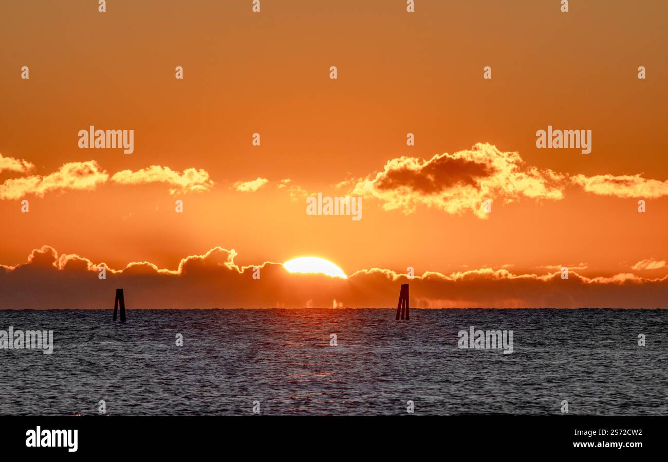 Fiery winter sunset taken with telephoto lens from the beach of Grado ...