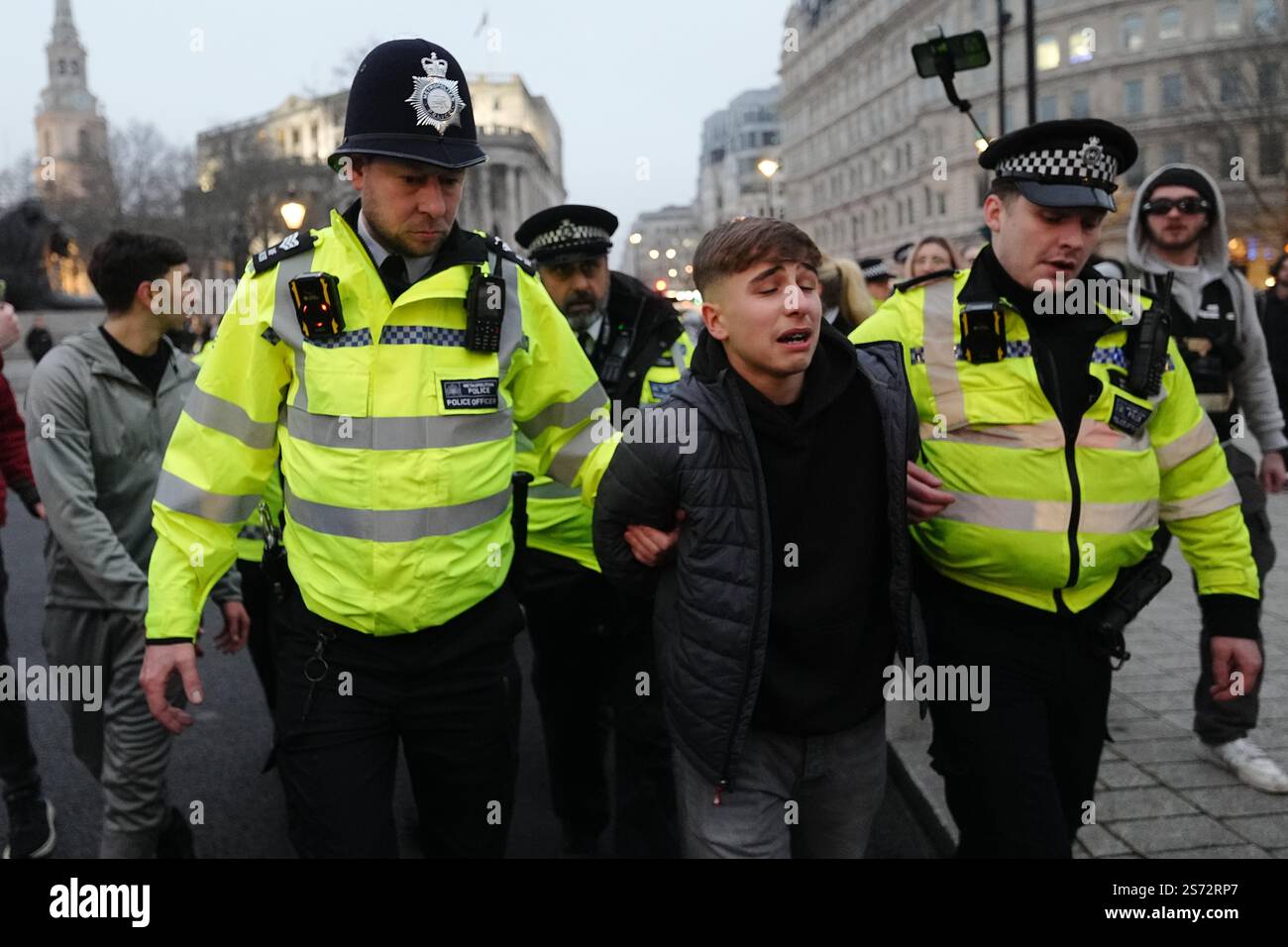 Police officers detain a person taking part in a national march for ...