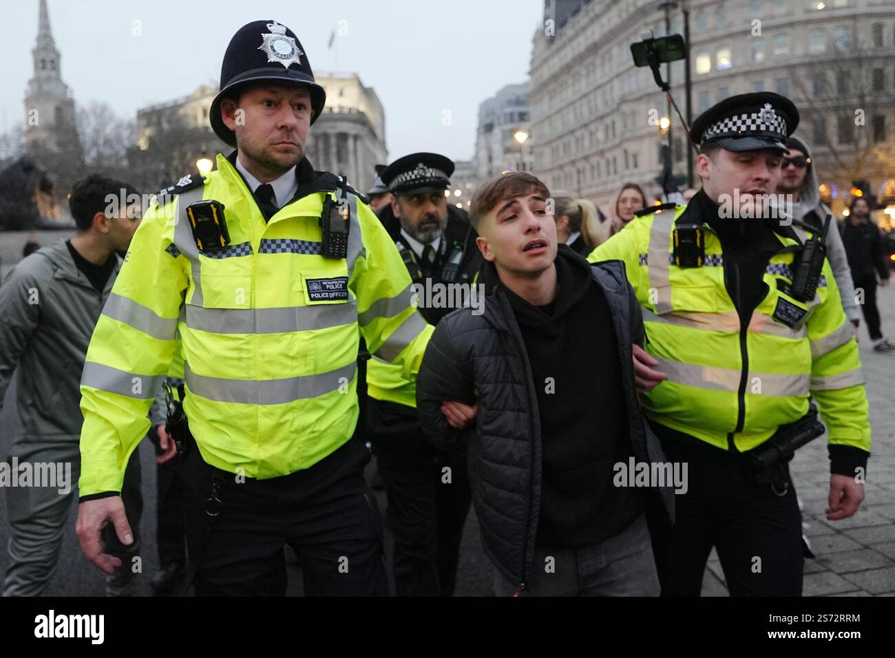Police officers detain a person taking part in a national march for ...