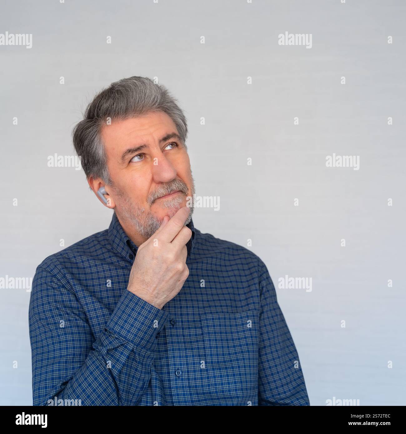 Senior white man looking up with doubtful face and thoughtful attitude ...