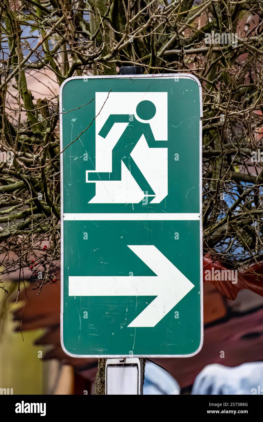 A green sign with a man running on it and an arrow pointing to the ...