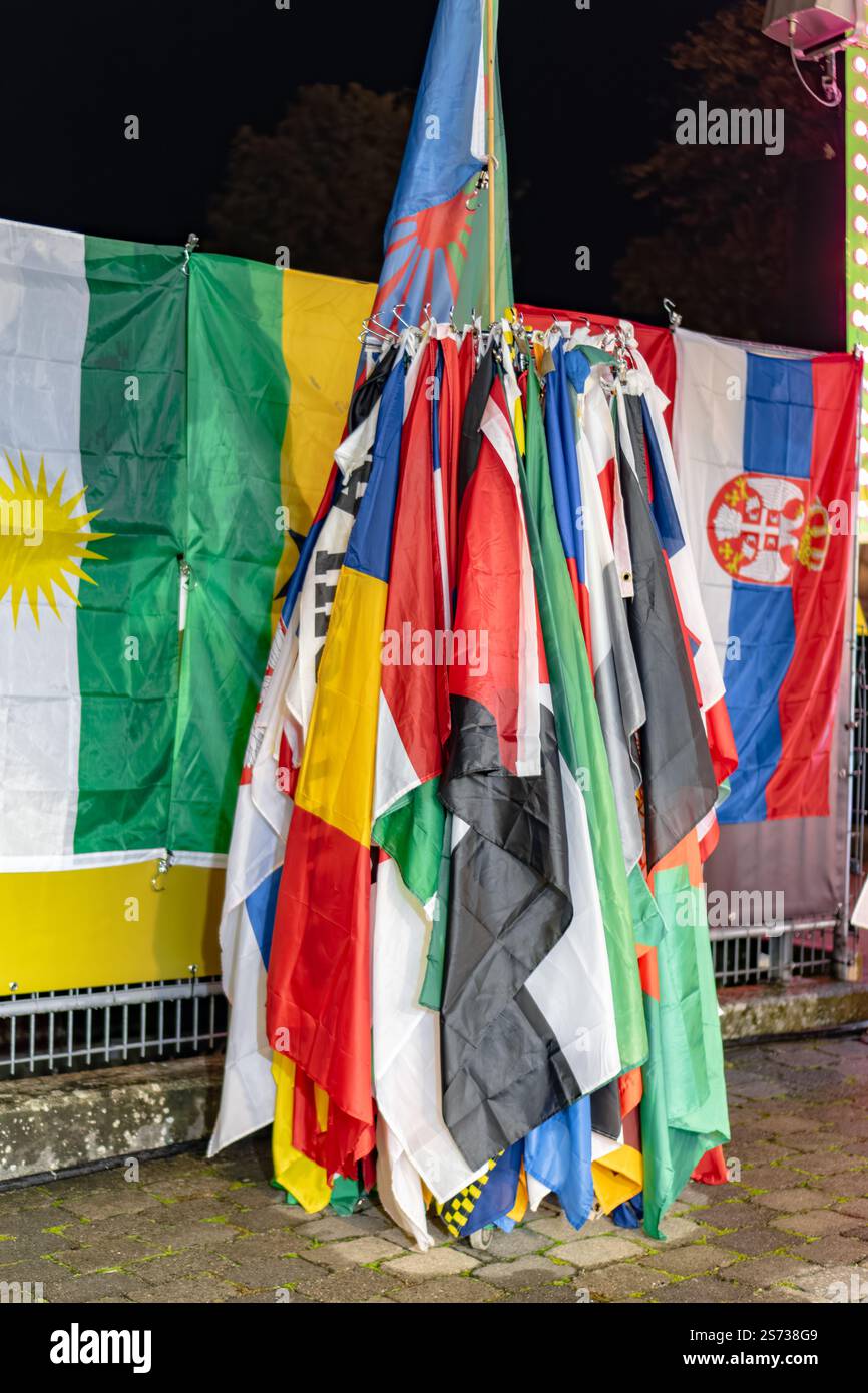 A large flag pole with many flags hanging from it. The flags are of ...
