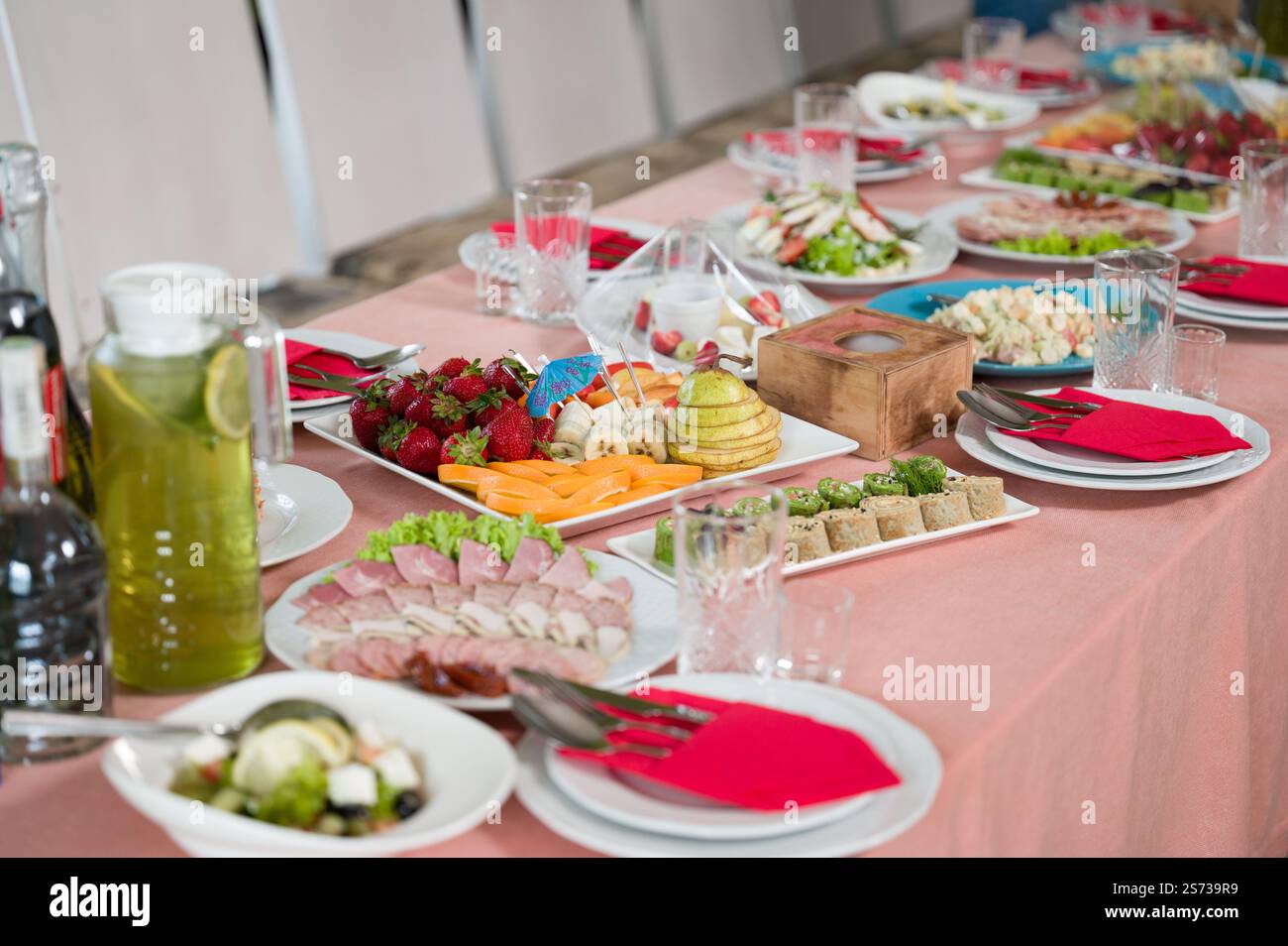 A lavish buffet table spread with various salads, meats, fruits, and appetizers, ready for a ...