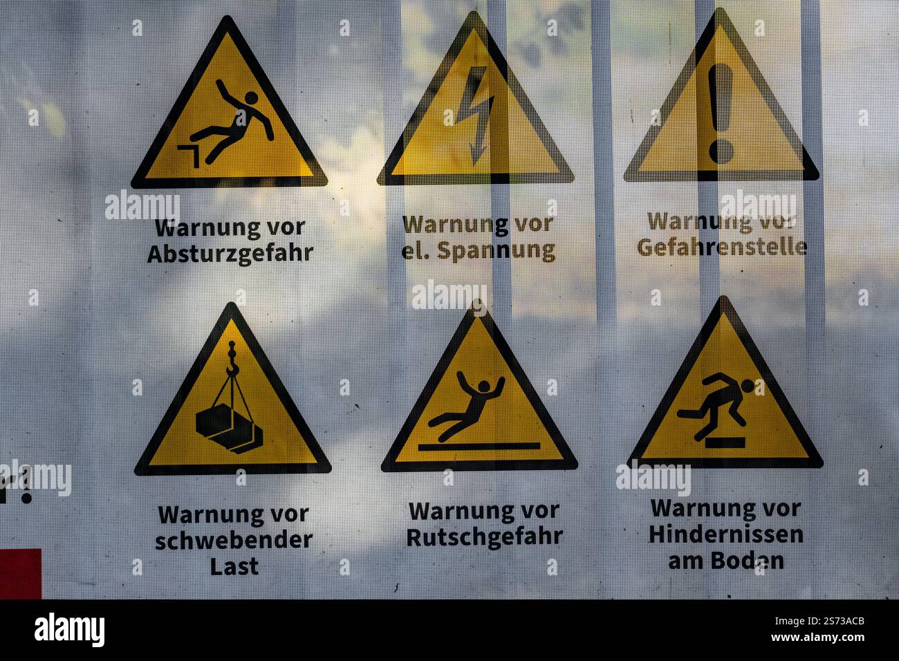 A sign with a yellow triangle and black writing that says "Warning" in ...