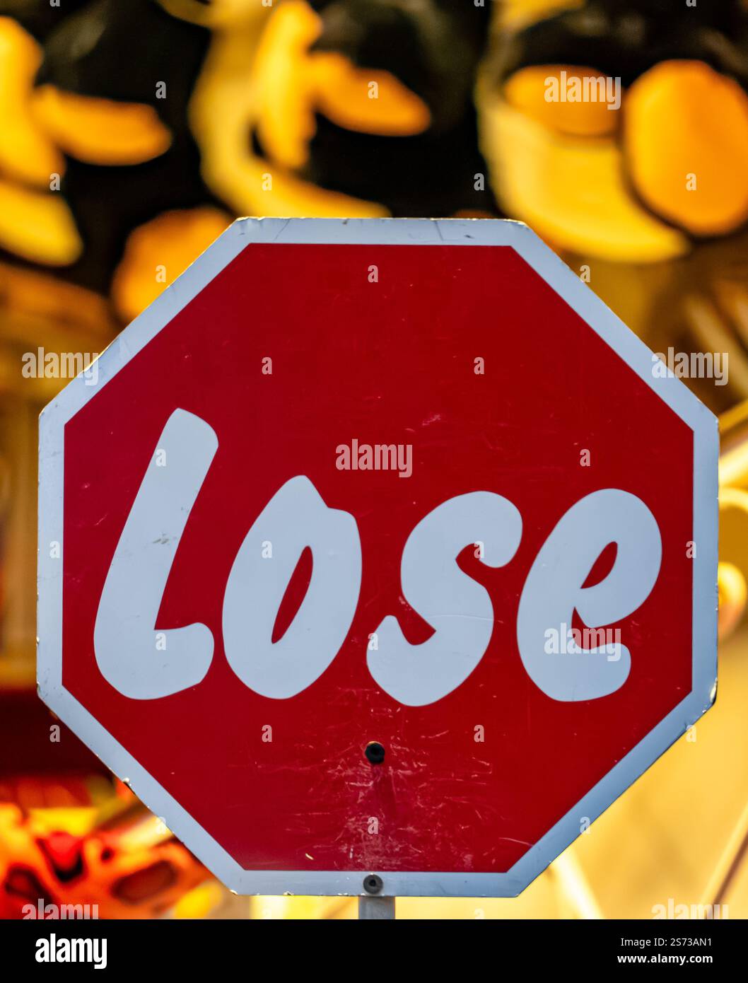 A stop sign with the word "LOSE" written on it. The sign is red and ...