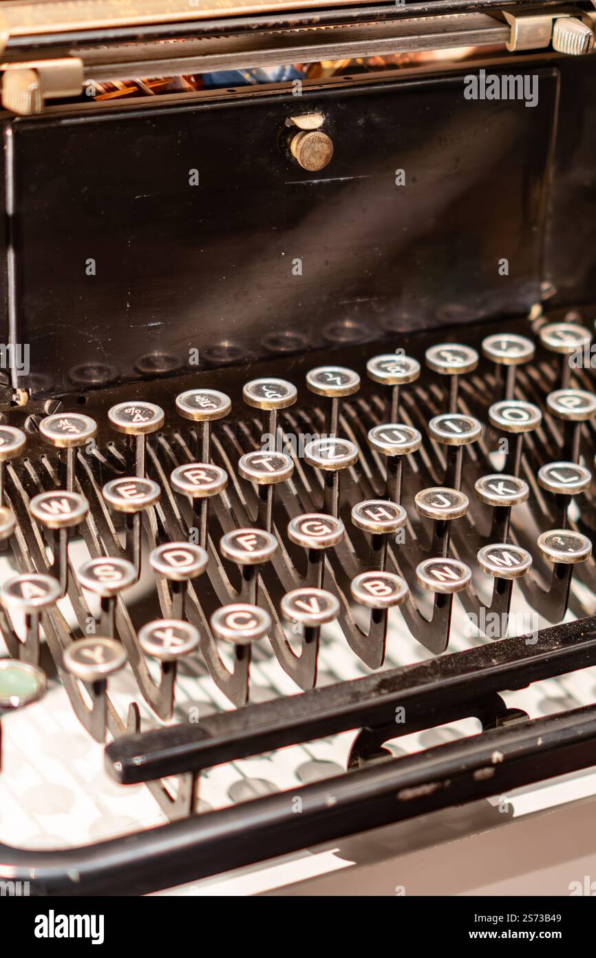A vintage typewriter with a black and white keyboard. The keys are ...