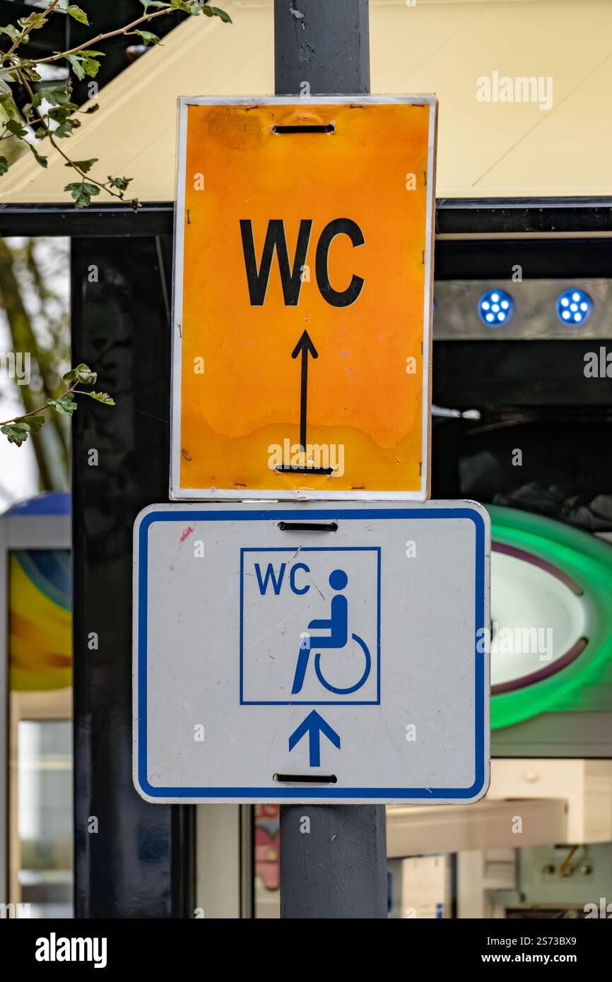 Two signs with a blue and white arrow pointing up and the word WC on ...