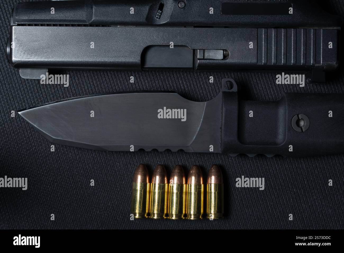 Compact pistol, 9mm ammo and a fixed blade tactical knife. Close up ...