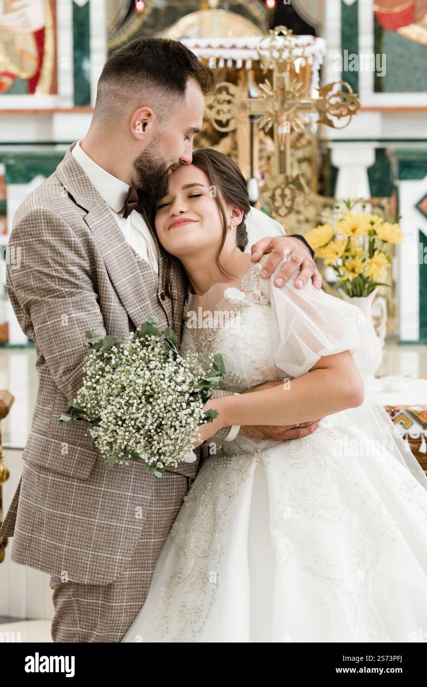 A newly married couple shares an intimate moment inside a church. The ...